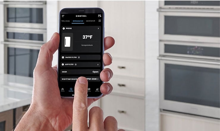 Hand holding a smartphone with a home automation app open, displaying ...